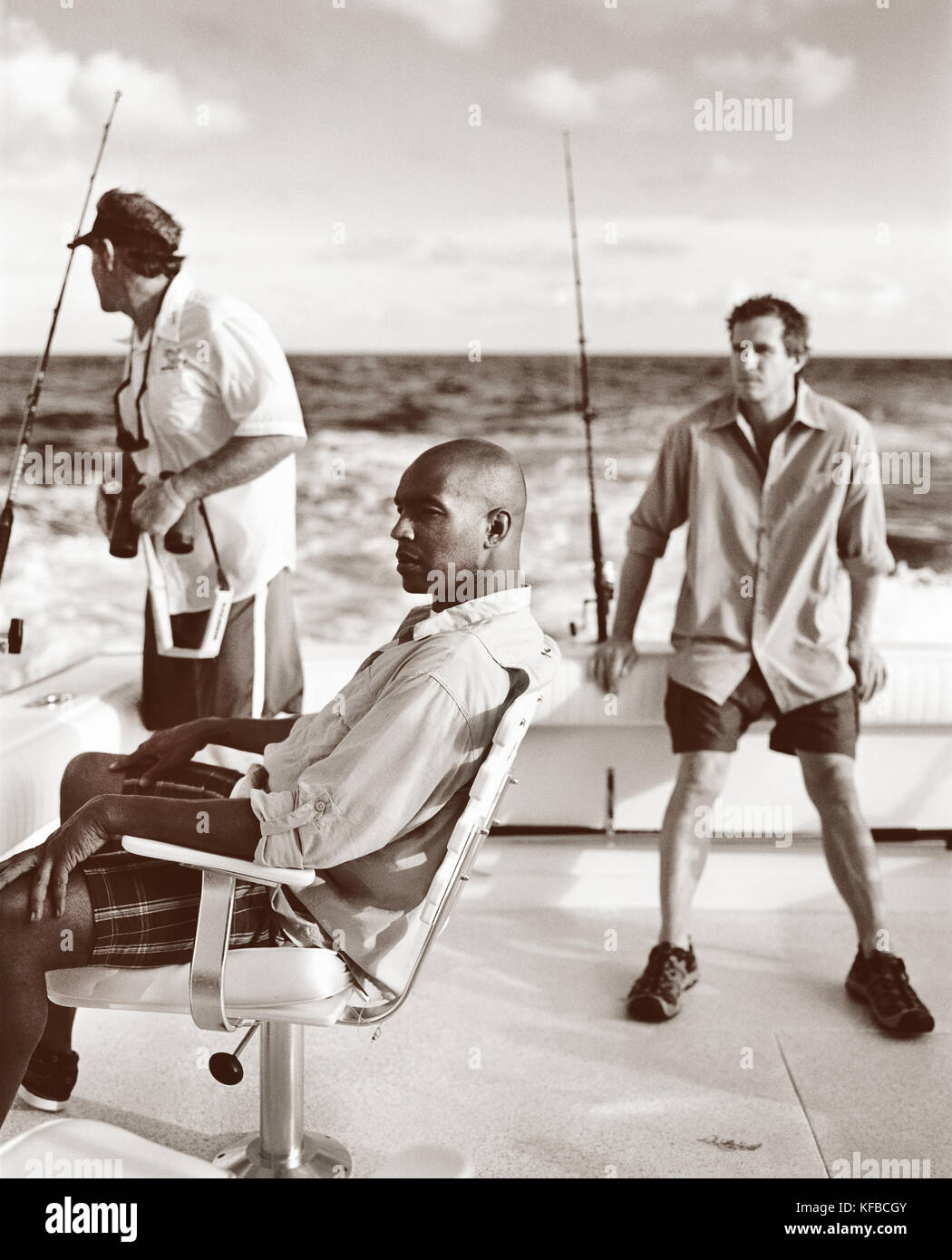USA, Florida, three men waiting for fish to hit the line, Islamorada (B ...