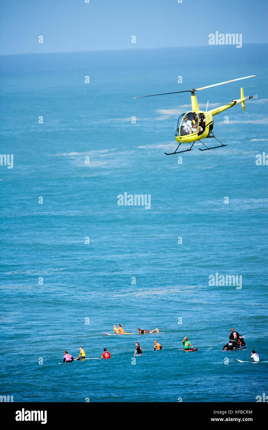 USA, Hawaii, Oahu, helicopter above surfers in the ocean at Waimea bay ...