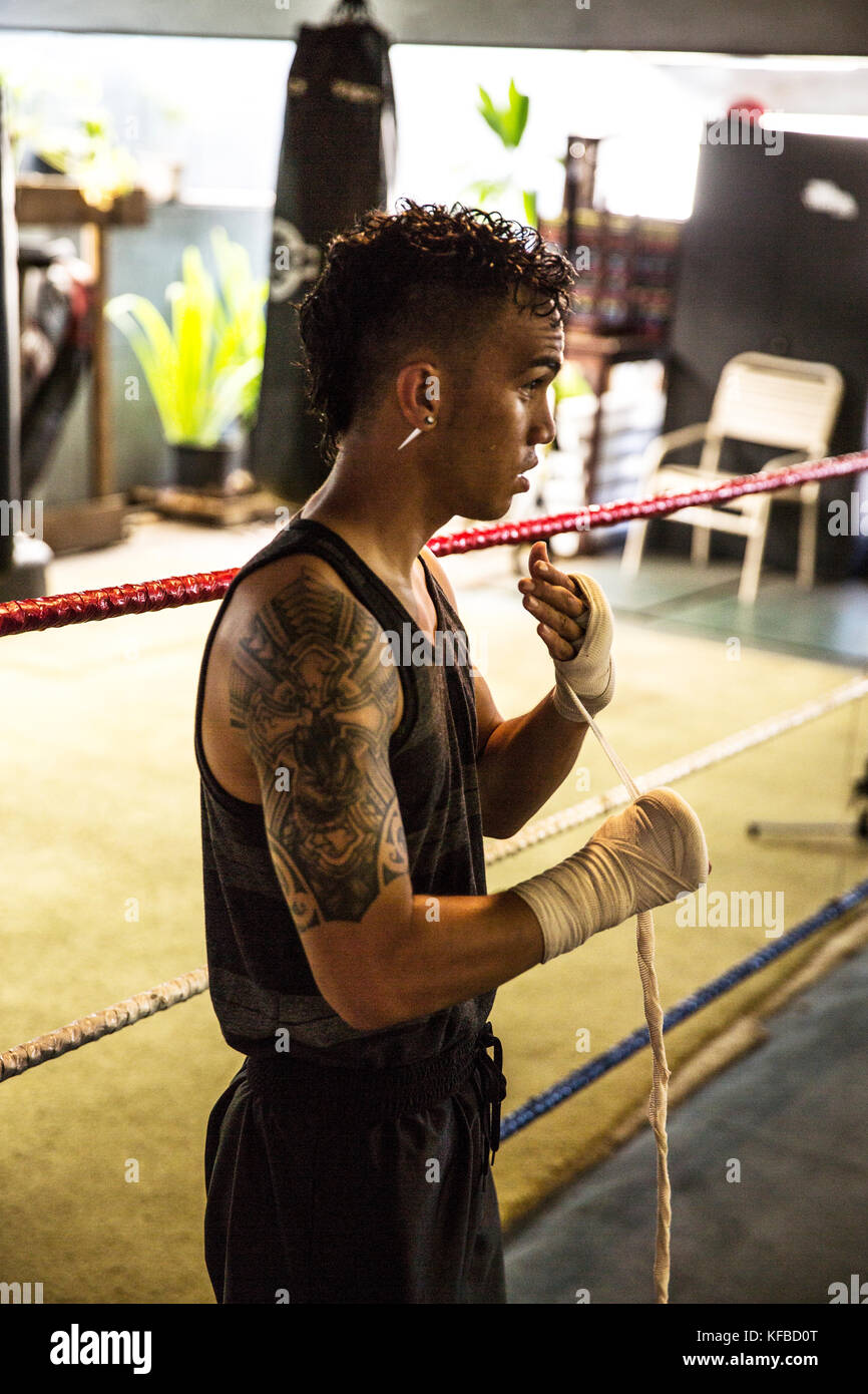 USA, Oahu, Hawaii, an up and coming boxer prepares his hands for a ...