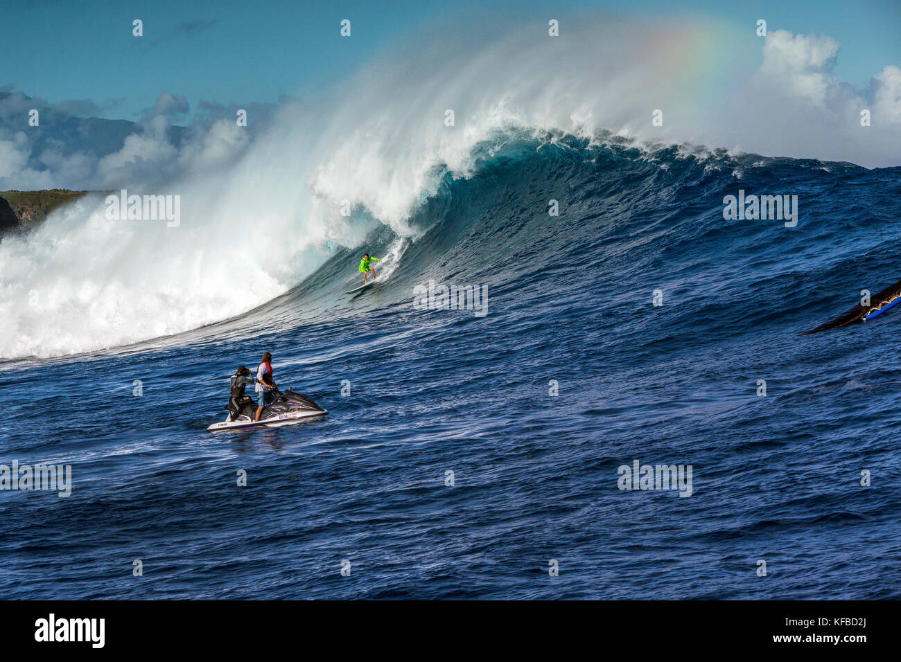 USA, HAWAII, Maui, Jaws, big wave surfers taking off on a wave at Peahi ...