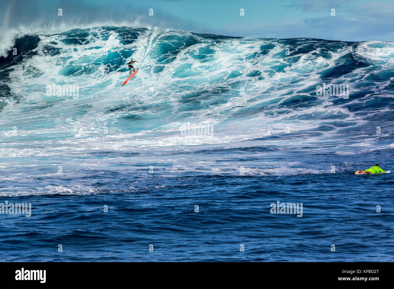 USA, HAWAII, Maui, Jaws, big wave surfers taking off on a wave at Peahi ...