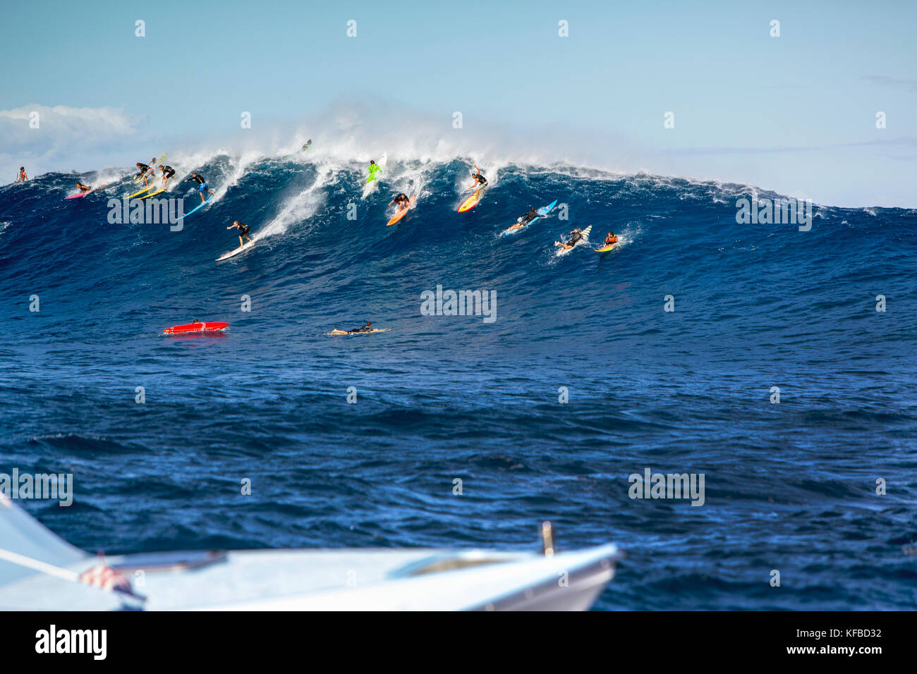 USA, HAWAII, Maui, Jaws, big wave surfers taking off on a wave at Peahi ...