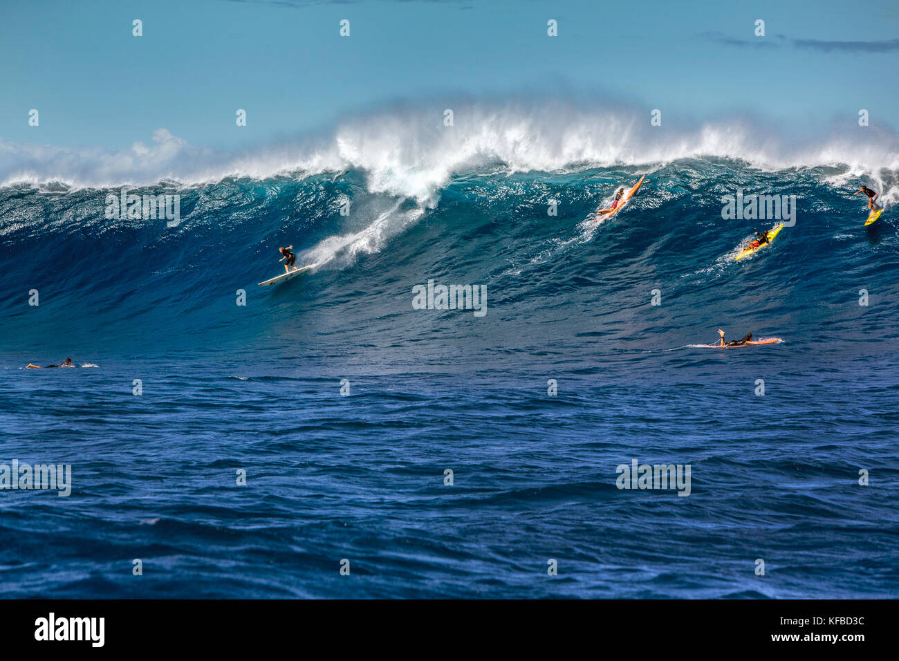 USA, HAWAII, Maui, Jaws, big wave surfers taking off on a wave at Peahi ...