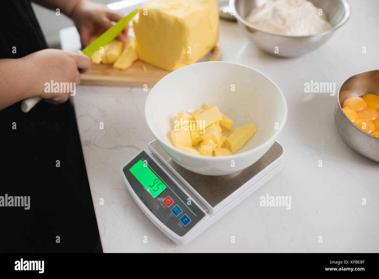 Cropped image of female chef cutting butter in kitchen Stock Photo - Alamy