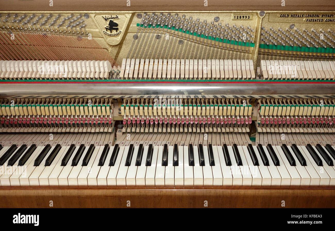 Upright piano stripped from upper front doors and fall showing keyboard ...