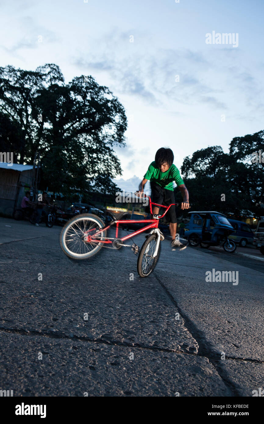 PHILIPPINES, Palawan, Puerto Princesa, boy does tricks on his bike in ...