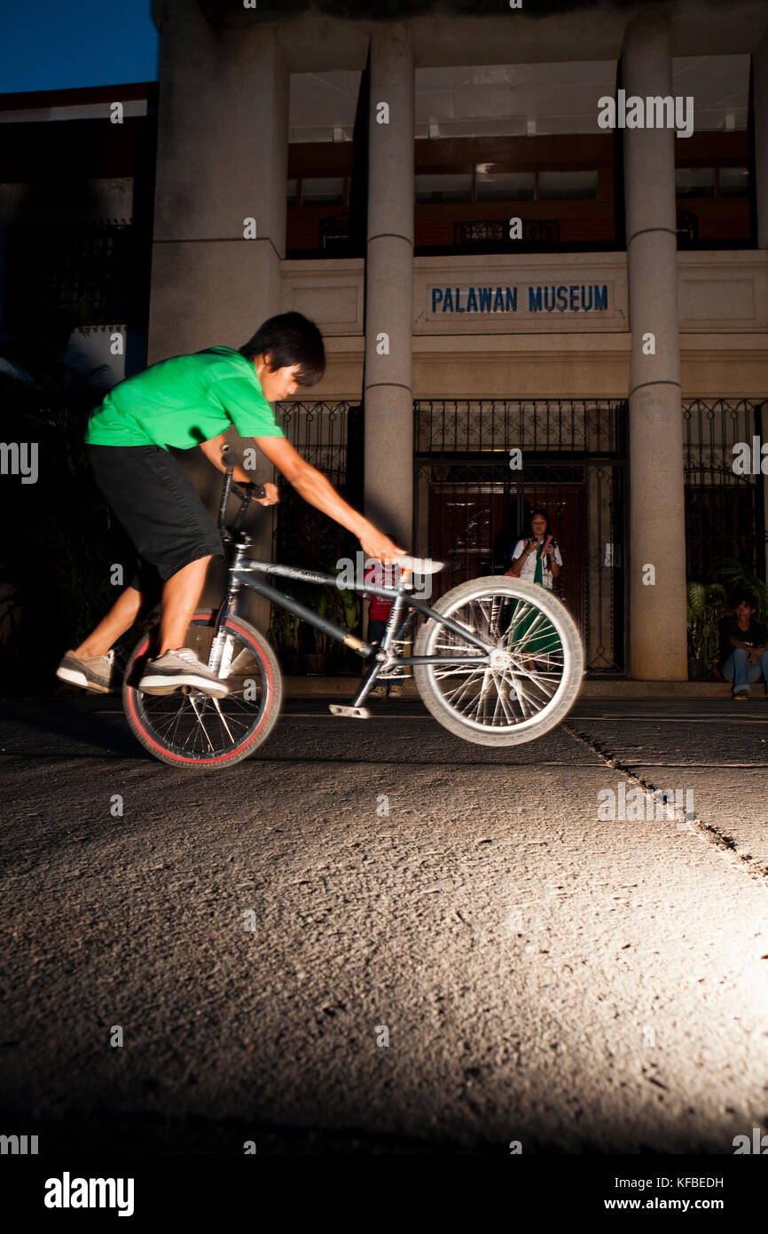 PHILIPPINES, Palawan, Puerto Princesa, boy does tricks on his bike in ...