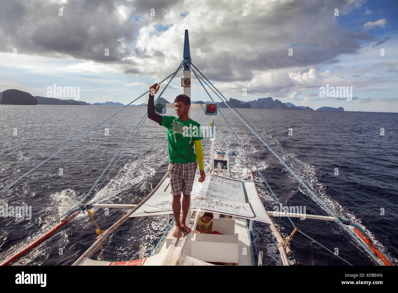 PHILIPPINES, Palawan, El Nido, Lagen Island, deck hand Eric keeps watch ...