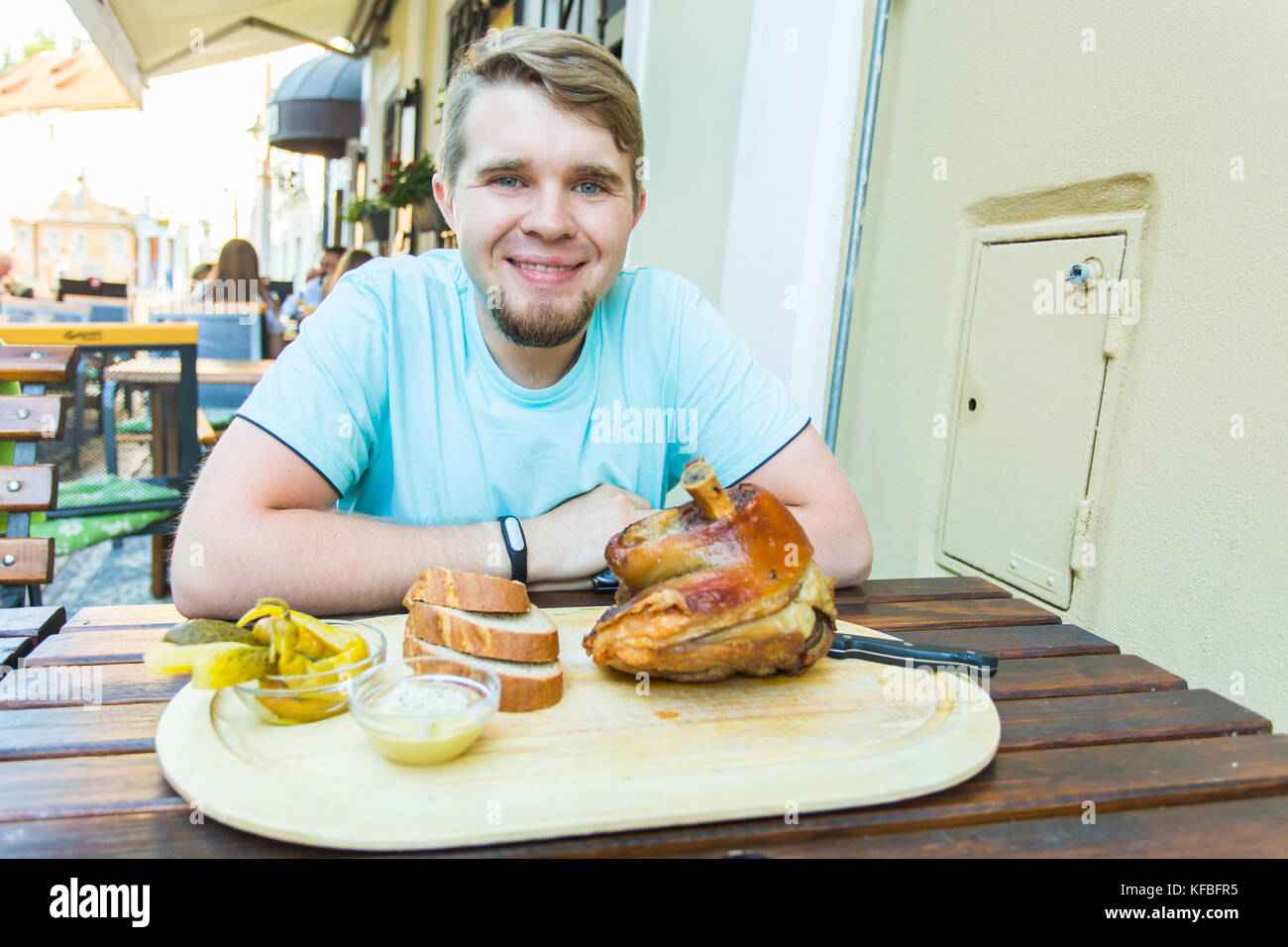 Man eating smoked pork meat and drinking beer Stock Photo - Alamy