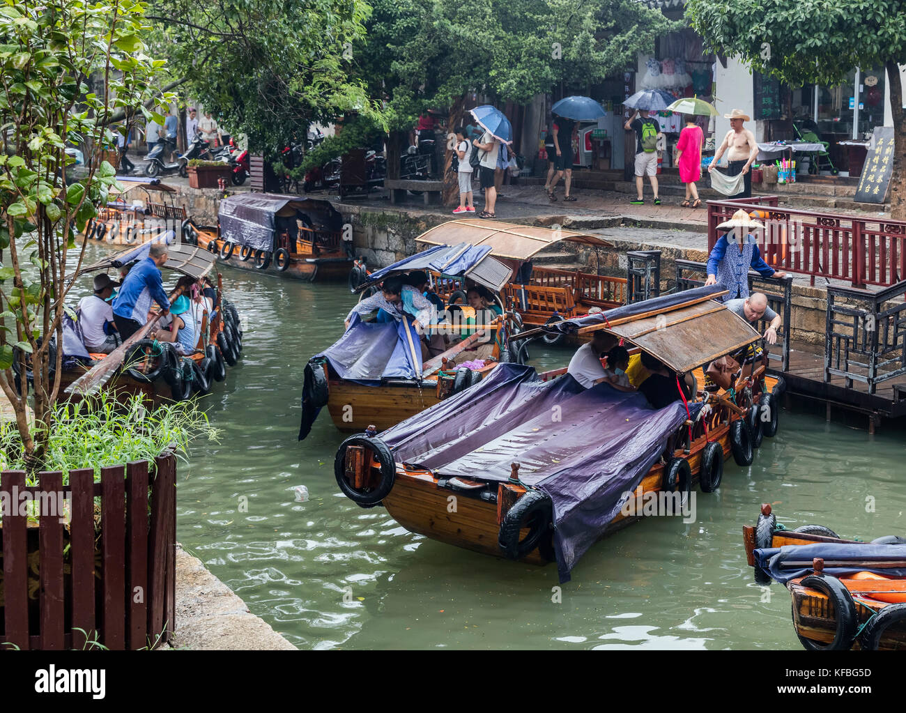 Stock Photo - Tourists ride in row boats in a canal in an ancient town ...