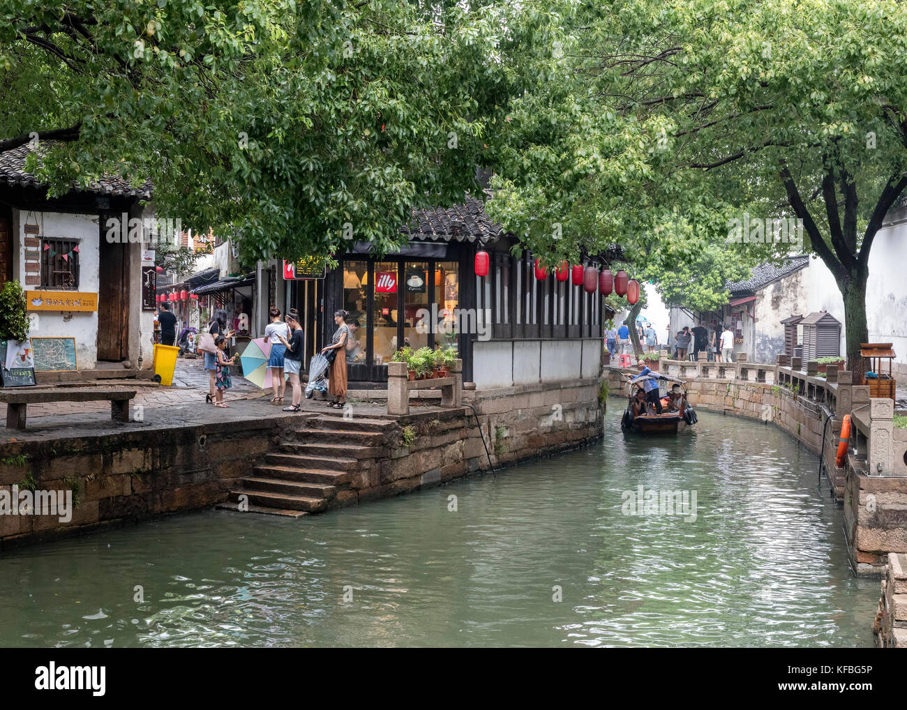 Stock Photo - Tourists ride in row boats in a canal in an ancient town ...