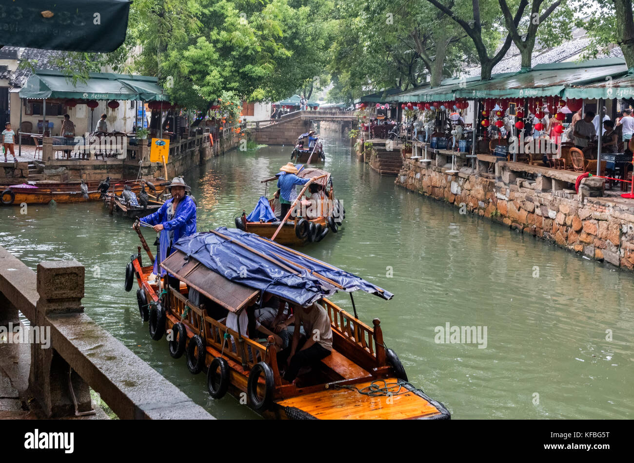 Stock Photo - Tourists ride in row boats in a canal in an ancient town ...