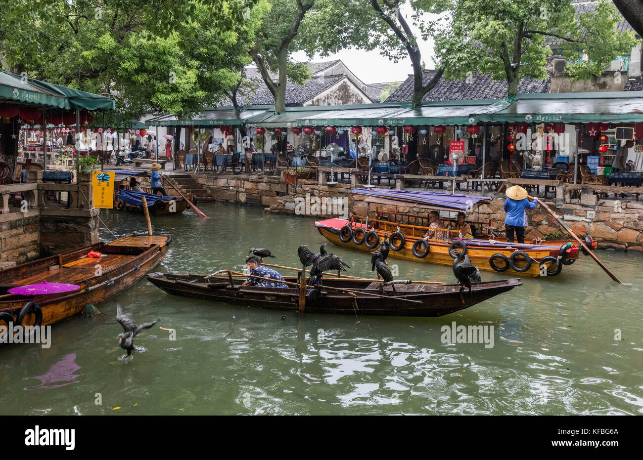 Stock Photo - Tourists ride in row boats in a canal in an ancient town ...