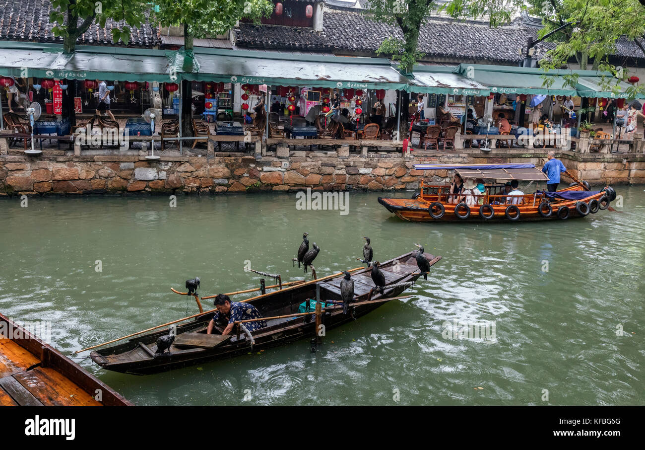 Stock Photo - Tourists ride in row boats in a canal in an ancient town ...