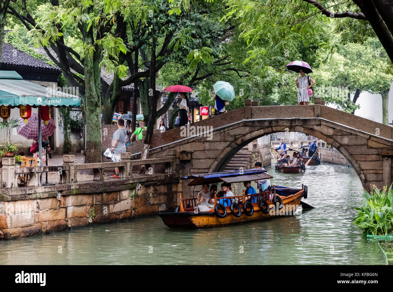 Stock Photo - Tourists ride in row boats in a canal in an ancient town ...