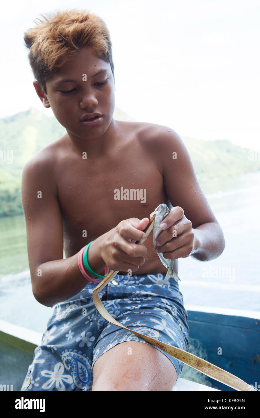 FRENCH POLYNESIA, Moorea. A young boy with his catch which he will ...