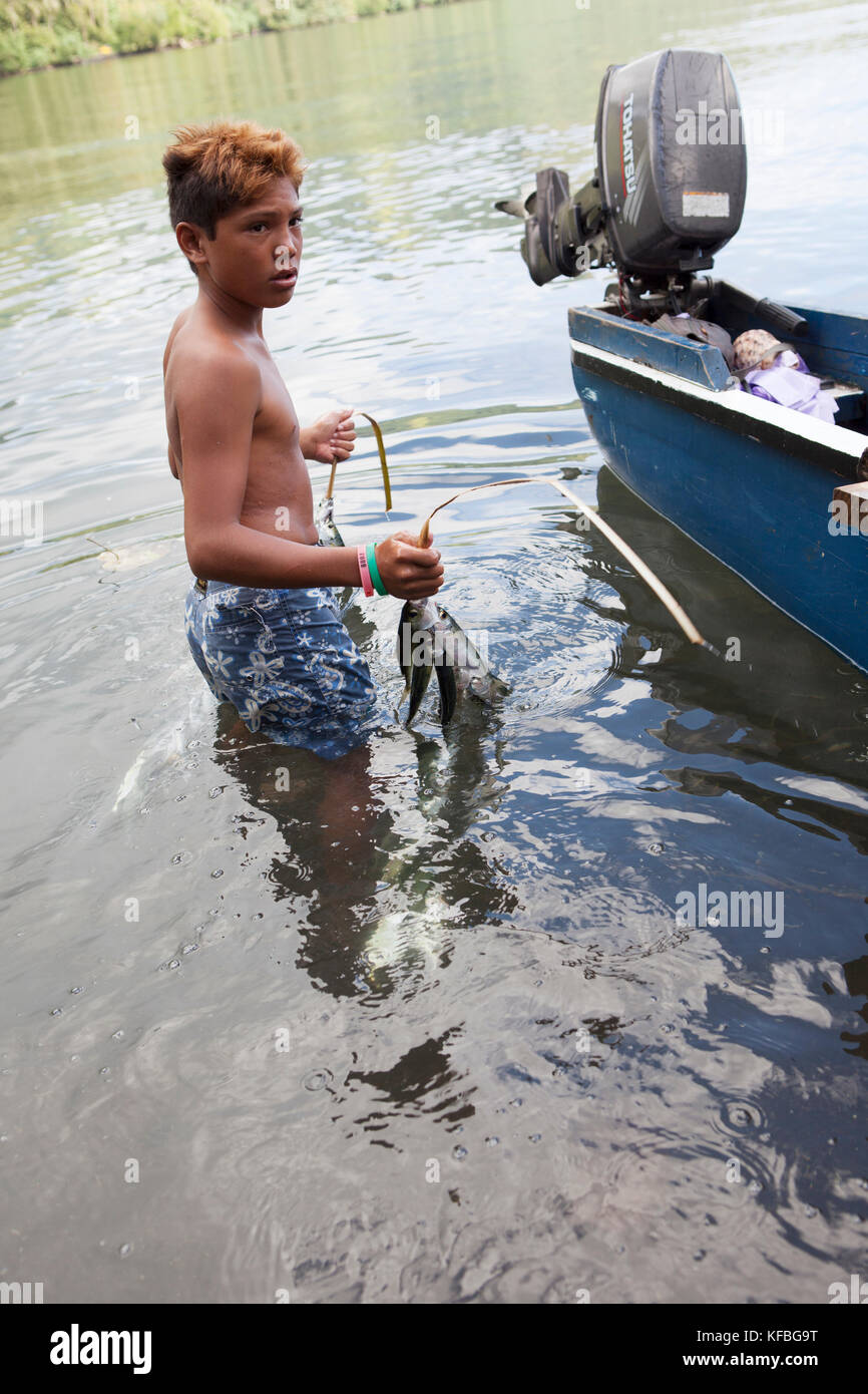 FRENCH POLYNESIA, Moorea. A young boy with his catch which he will ...