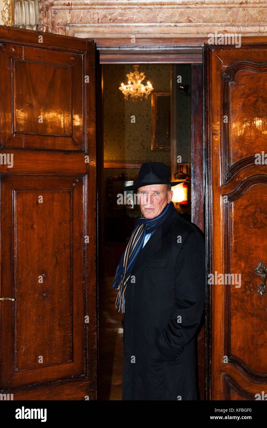 ITALY, Venice. Actor Peter Weller standing in the doorway of his room ...