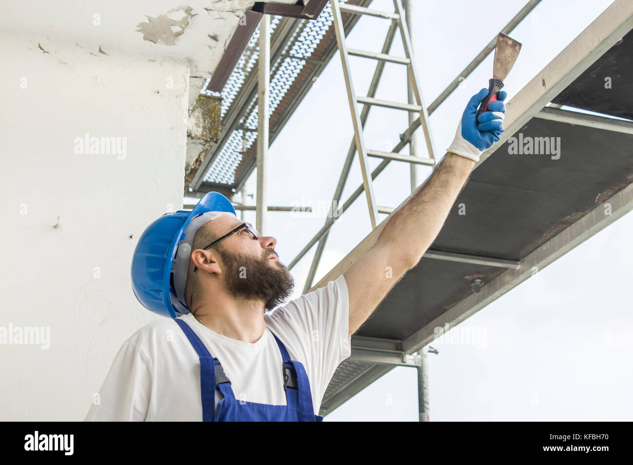 construction worker in a work attire, protective gloves and a helmet on ...