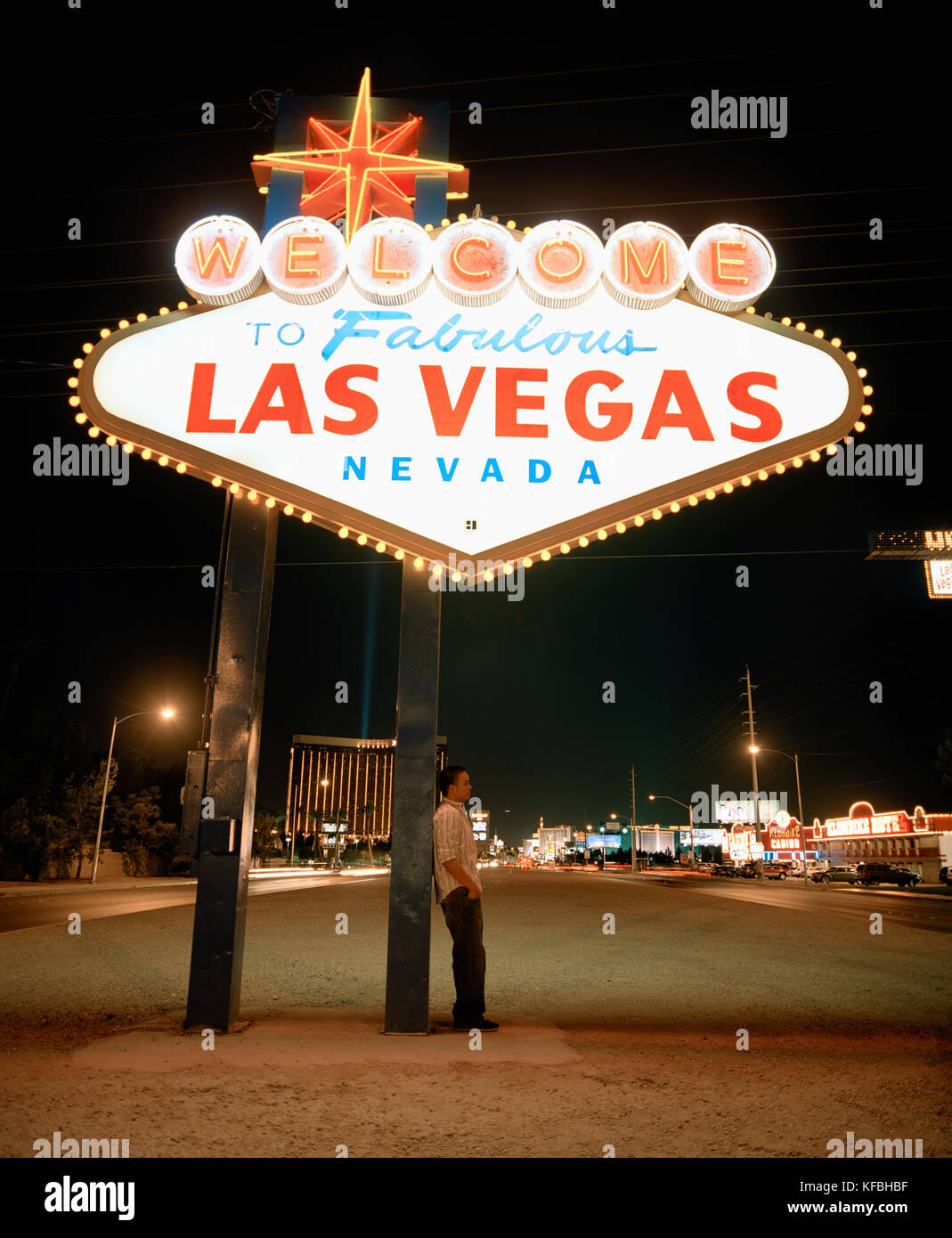 USA, Nevada, young man standing under welcome sign of Las Vegas at ...