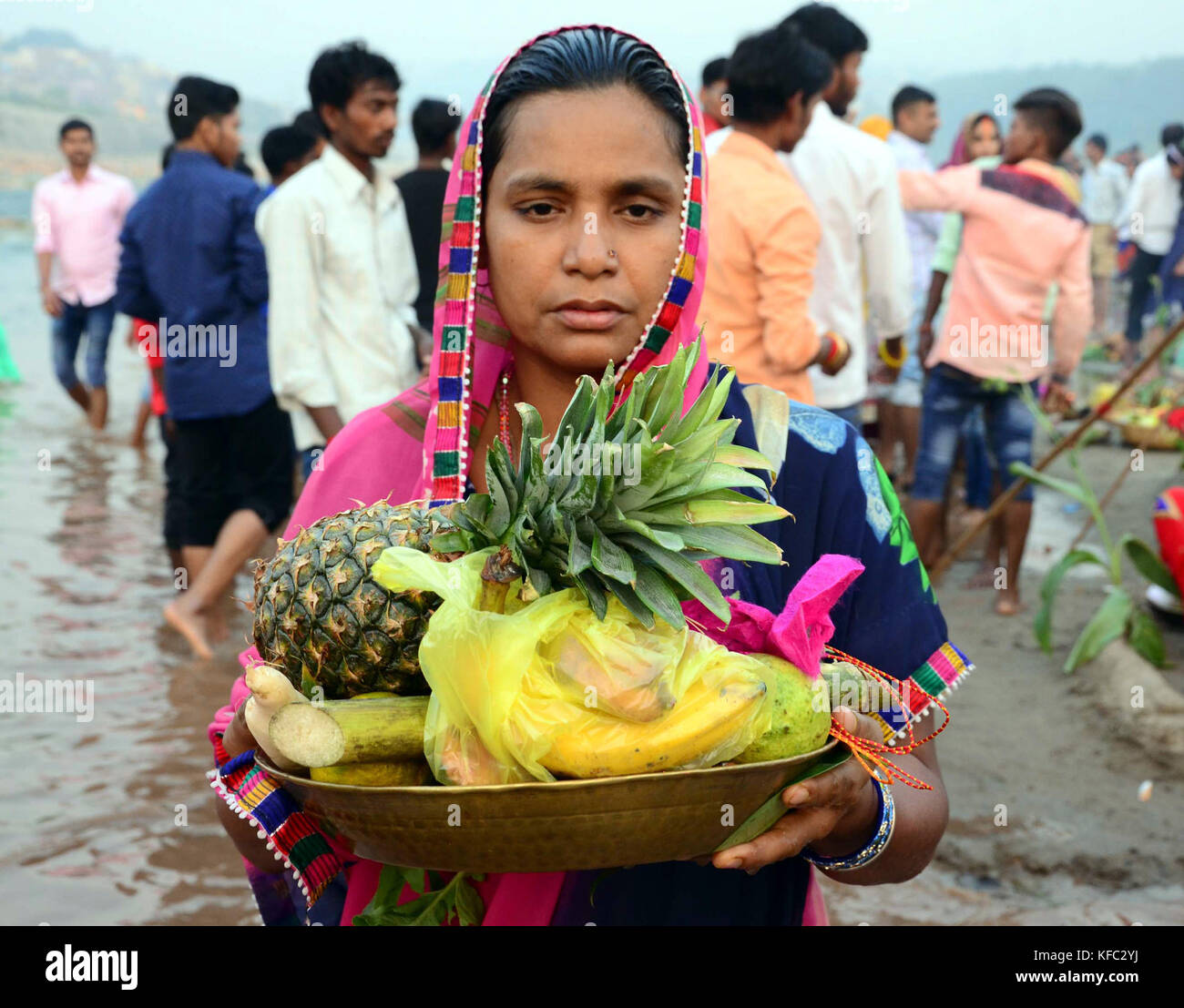 An Indian devotee receives a Tika, a red mark on her forehead, as she ...