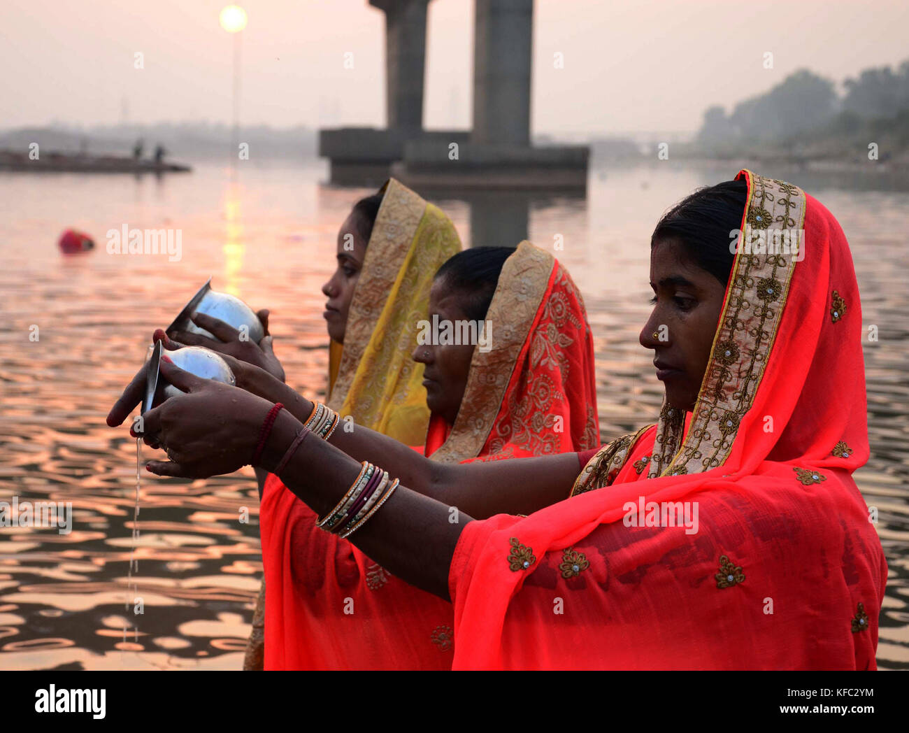 An Indian devotee receives a Tika, a red mark on her forehead, as she ...