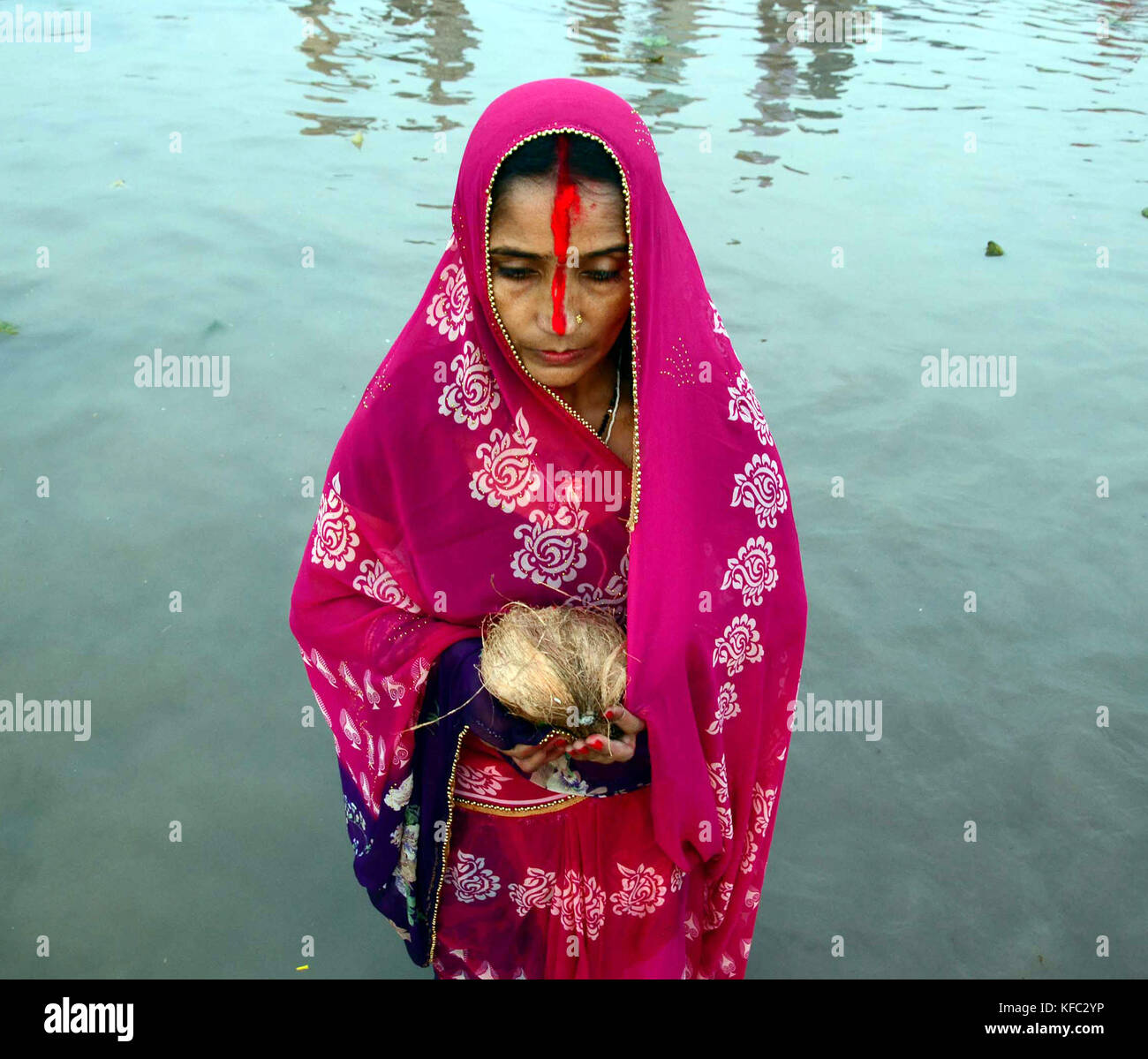 An Indian devotee receives a Tika, a red mark on her forehead, as she ...