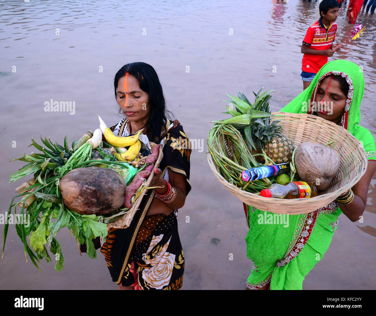 An Indian devotee receives a Tika, a red mark on her forehead, as she ...