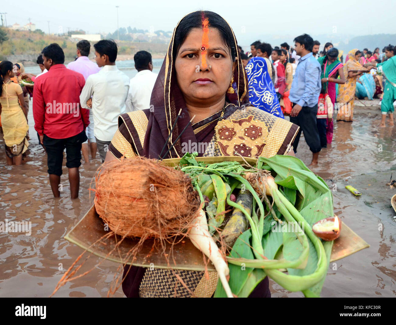 An Indian devotee receives a Tika, a red mark on her forehead, as she ...