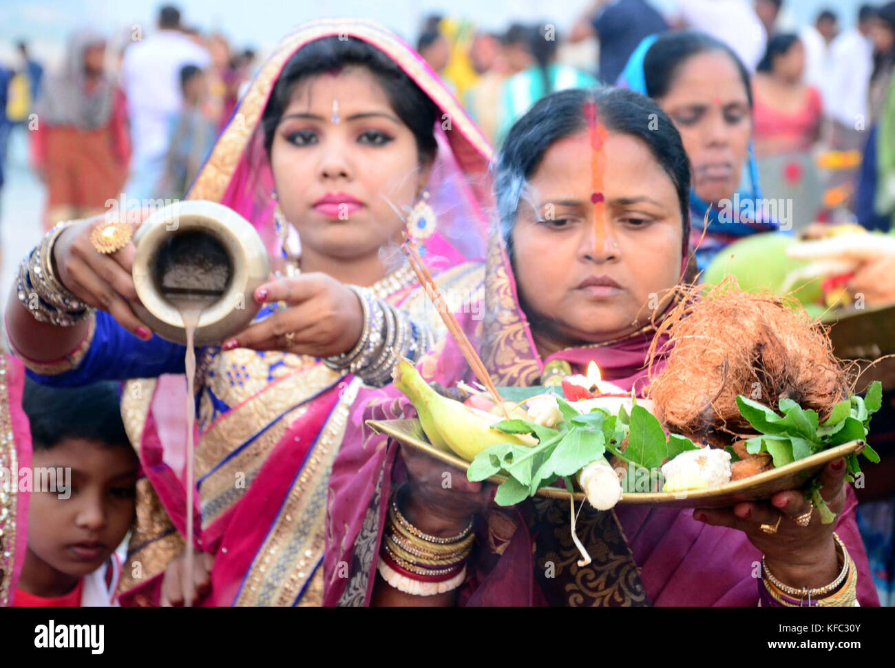An Indian devotee receives a Tika, a red mark on her forehead, as she ...