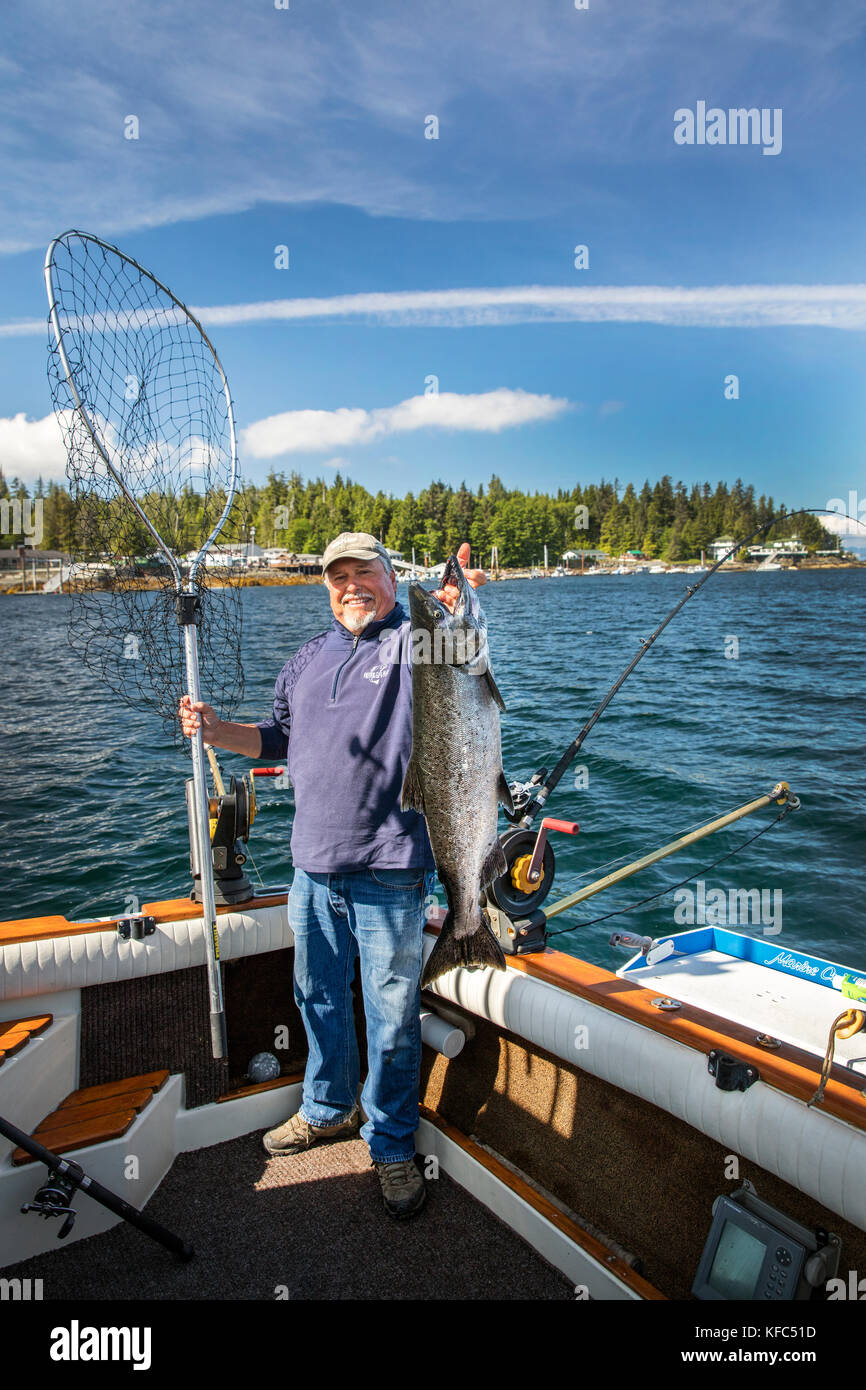 USA, Alaska, Ketchikan, Captain Tony shows off his catch while fishing ...