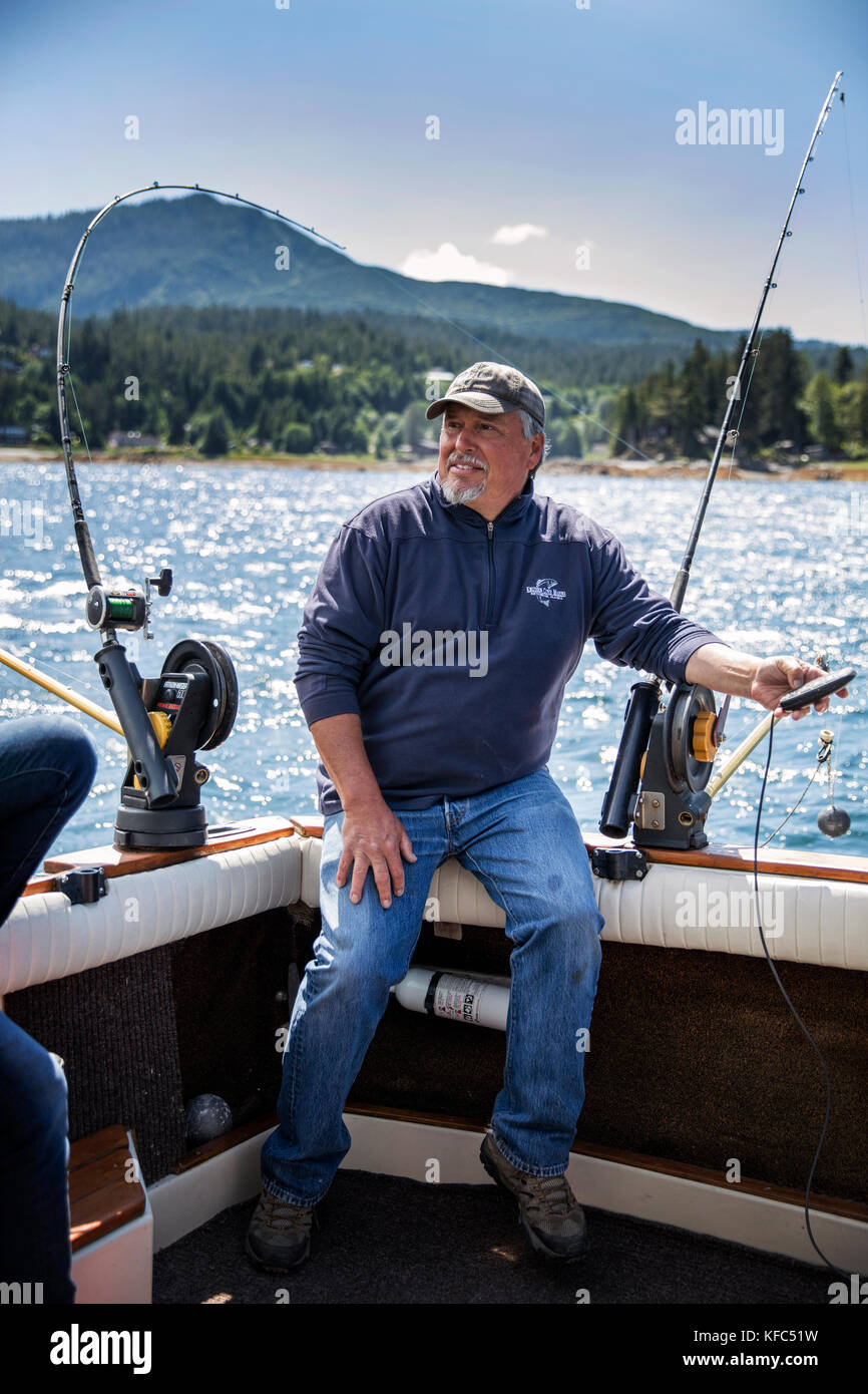 USA, Alaska, Ketchikan, Captain Tony tends to his lines while fishing ...