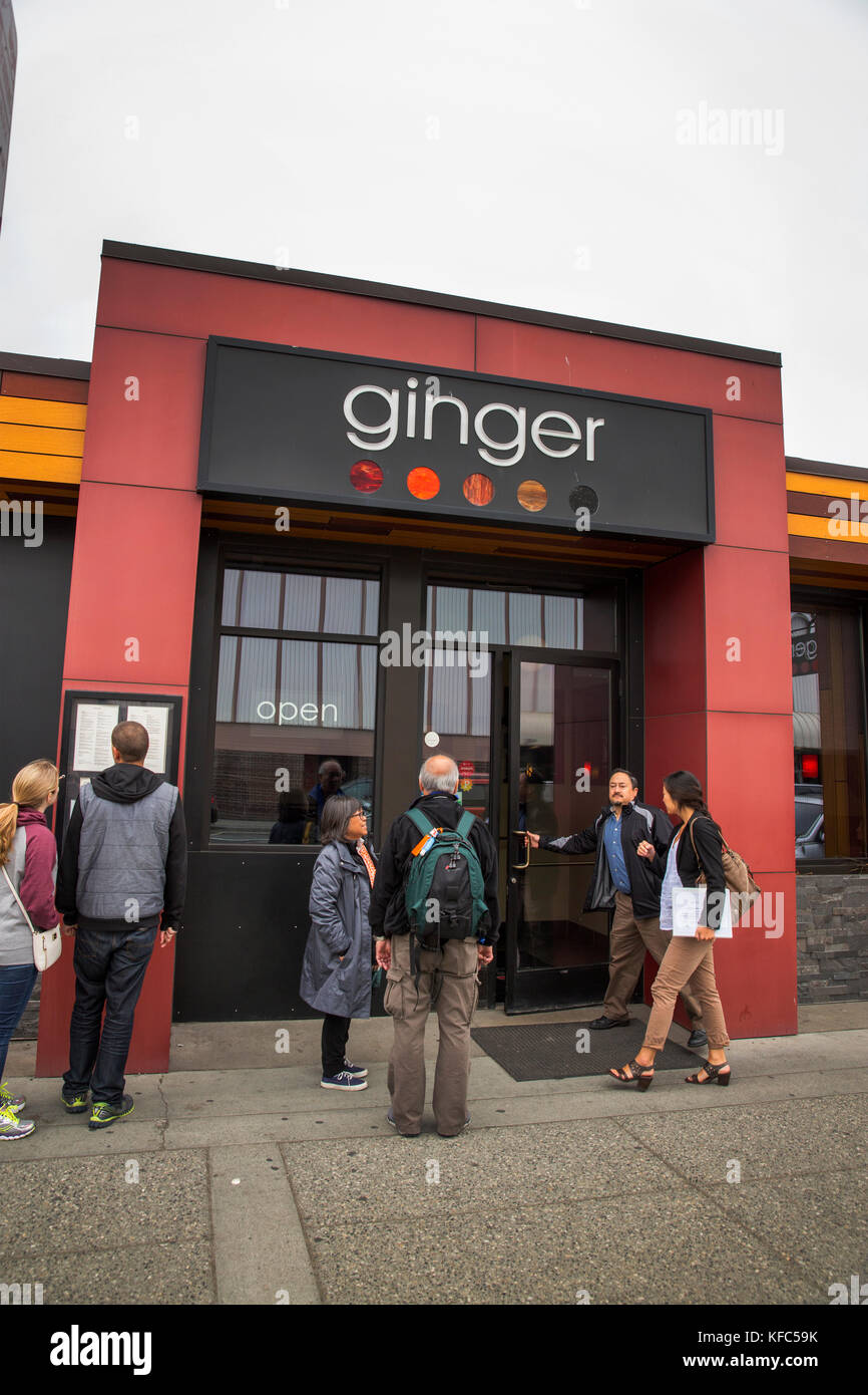 USA, Alaska, Anchorage, individuals stand outside and read the menu at ...