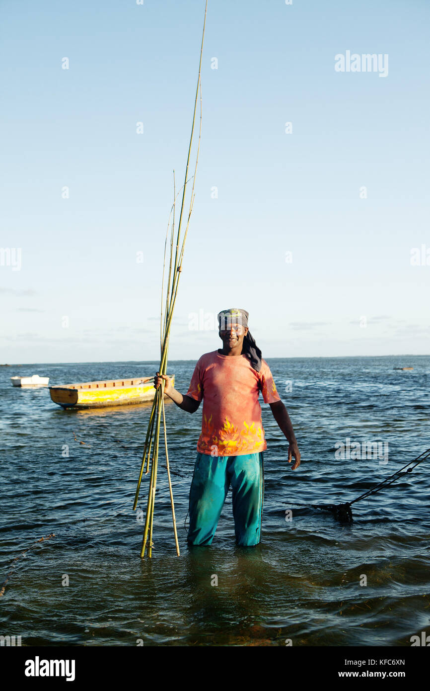 MAURITIUS, portrait of a fishermen with a bunch of handmade bamboo ...