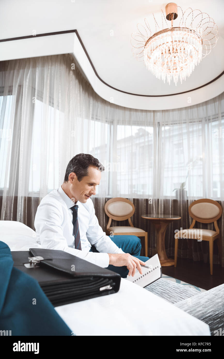 Businessman reading notebook Stock Photo - Alamy