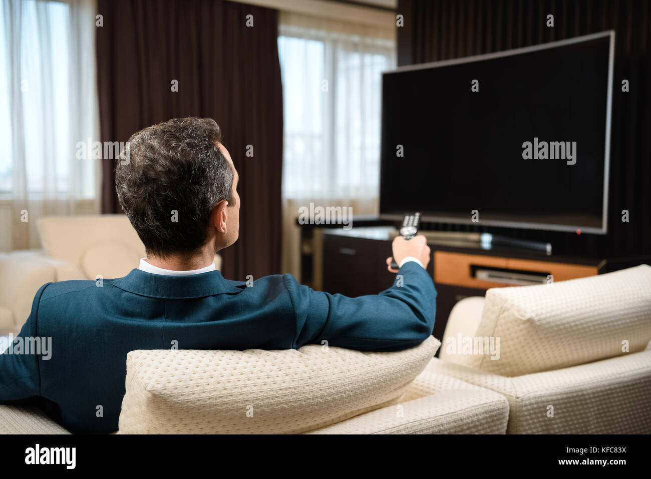 Sitting holding watching television communication technology hi-res ...