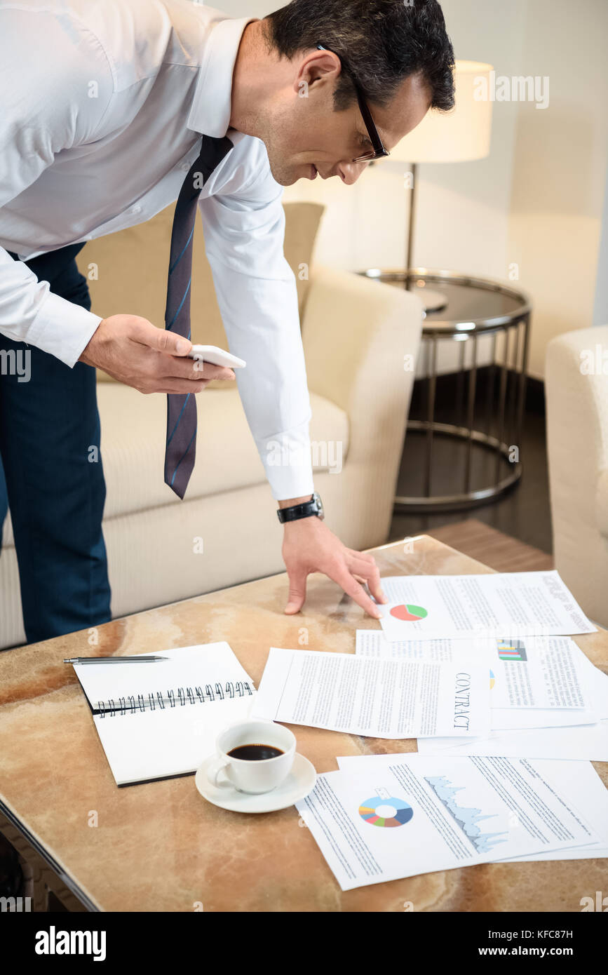 Businessman reading paperwork Stock Photo - Alamy