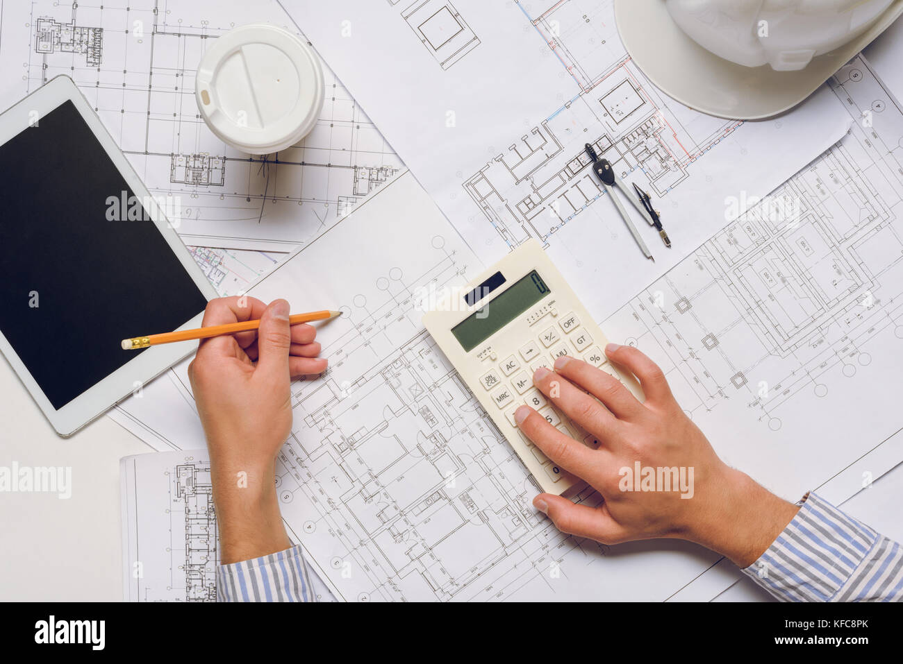 architect working with blueprints and calculator Stock Photo - Alamy
