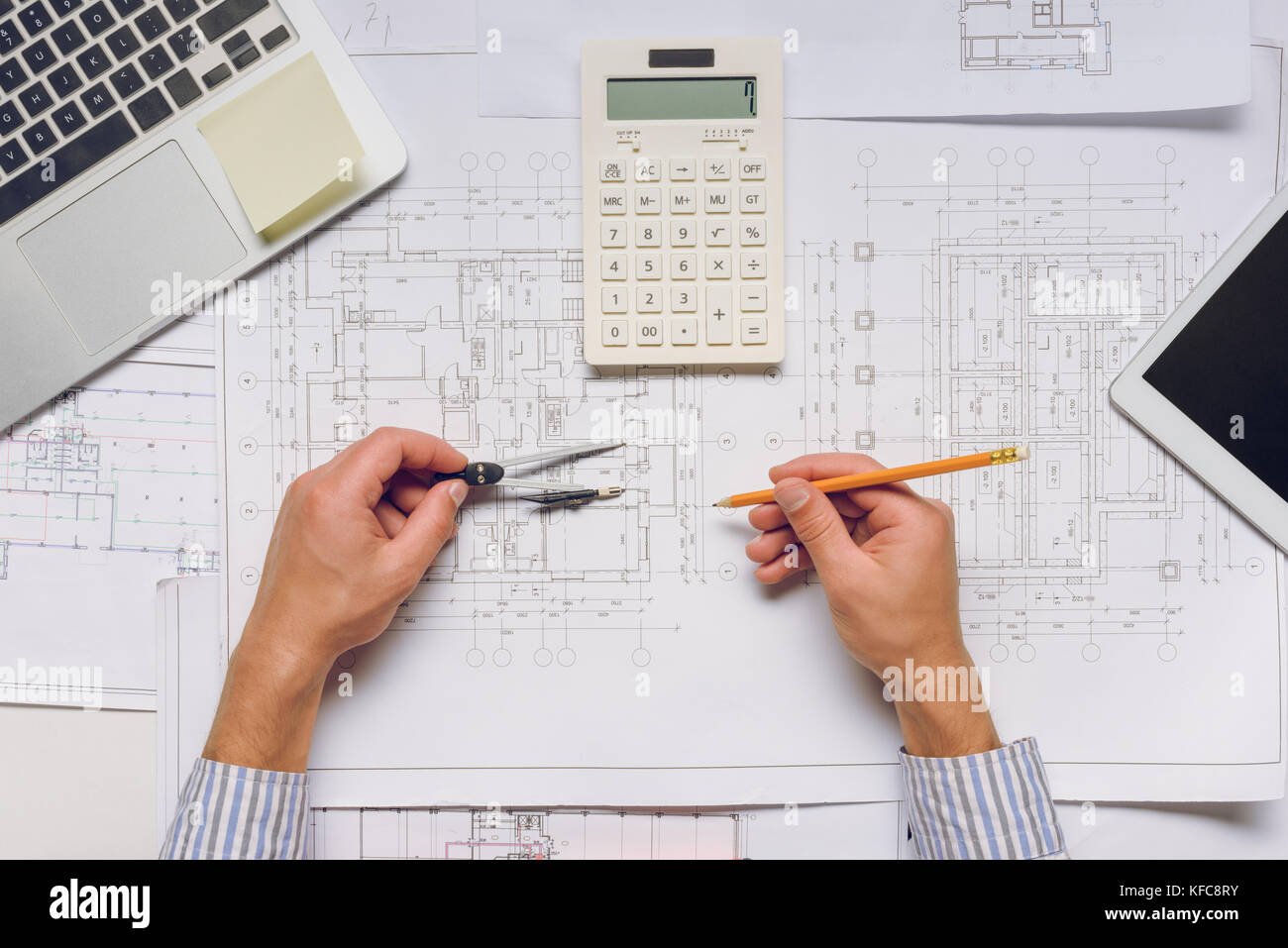 architect working with blueprints and calculator Stock Photo - Alamy
