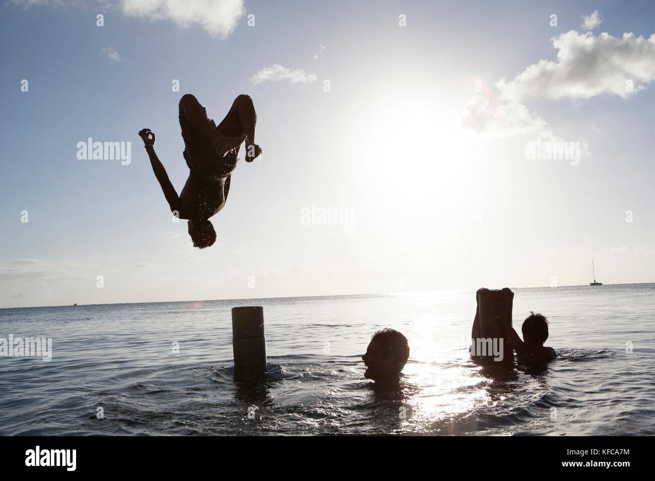FRENCH POLYNESIA, Raiatea Island. Local kids swimming and playing along ...