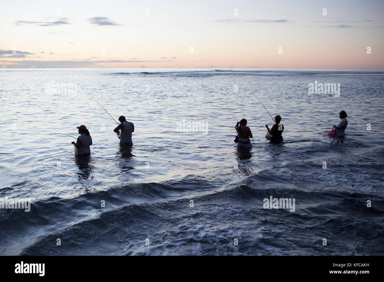 FRENCH POLYNESIA, Tahiti. Black sand beach in Tahiti. Locals fishing in ...