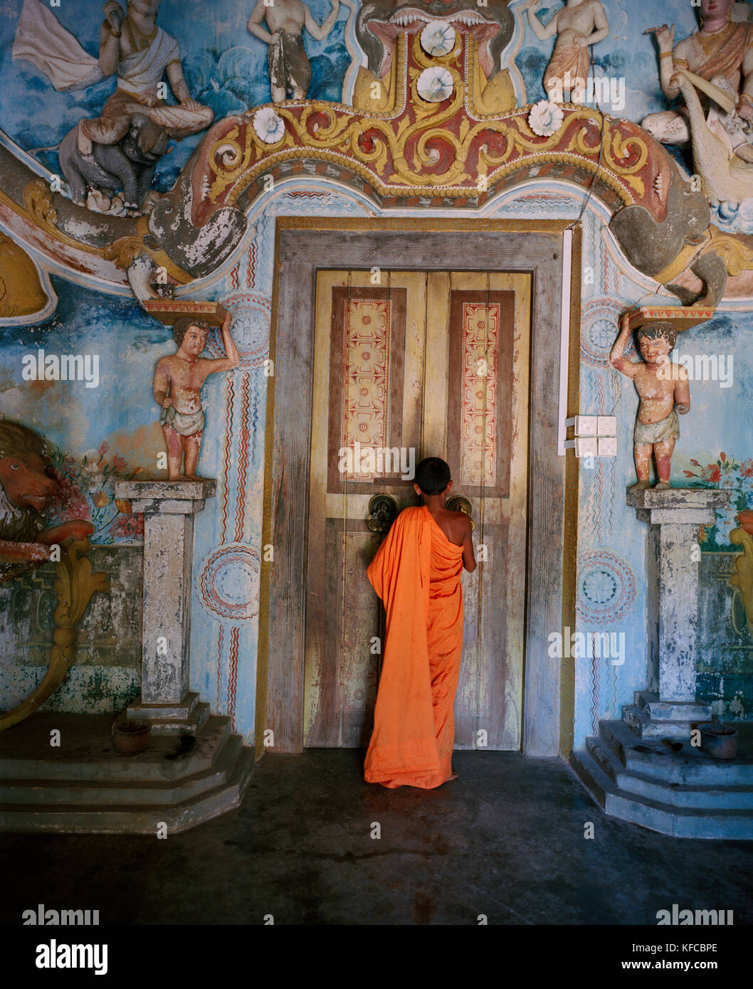 SRI LANKA, Asia, rear view of a monk standing in front of temple's door ...