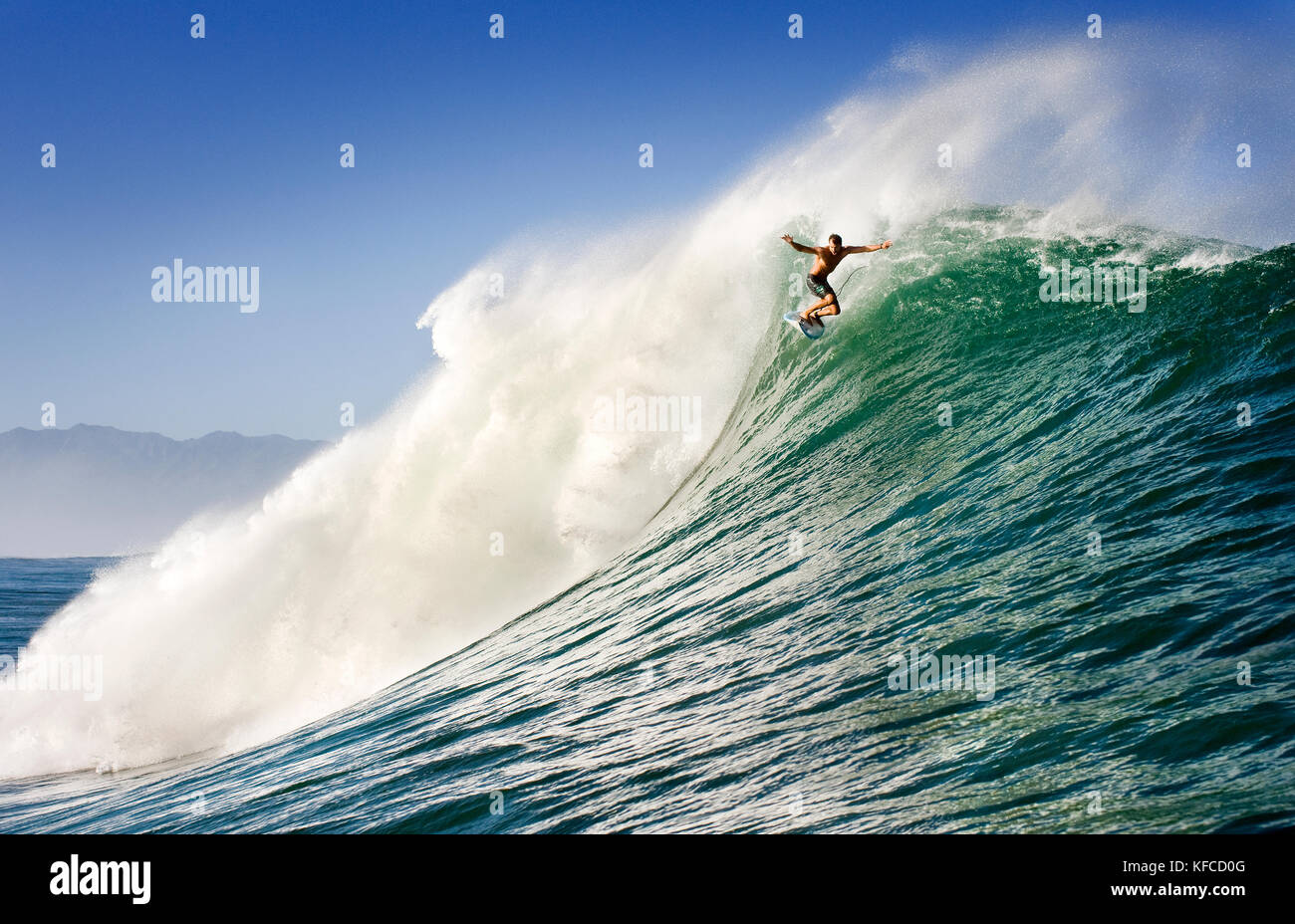 USA, Hawaii, man surfs a large wave on an outer reef, the North Shore ...