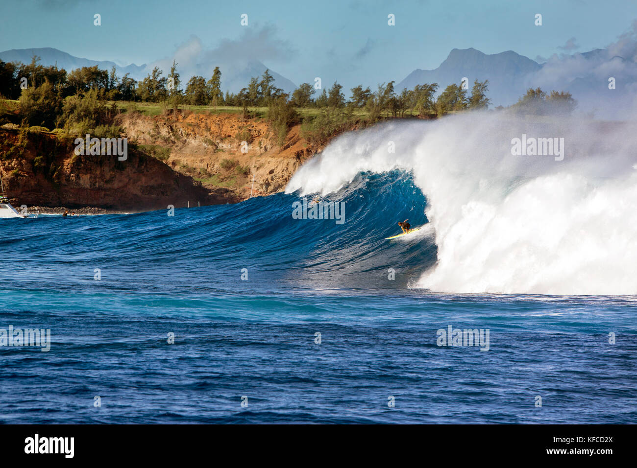 USA, HAWAII, Maui, Jaws, big wave surfers taking off on a wave at Peahi ...