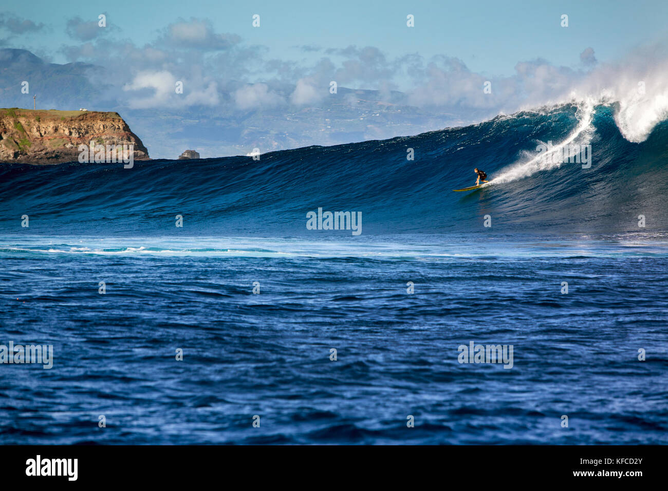 USA, HAWAII, Maui, Jaws, big wave surfers taking off on a wave at Peahi ...