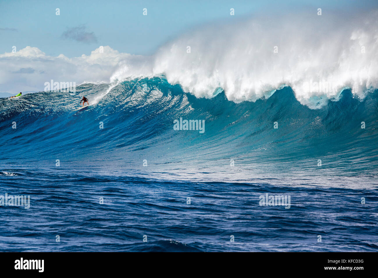 USA, HAWAII, Maui, Jaws, big wave surfers taking off on a wave at Peahi ...