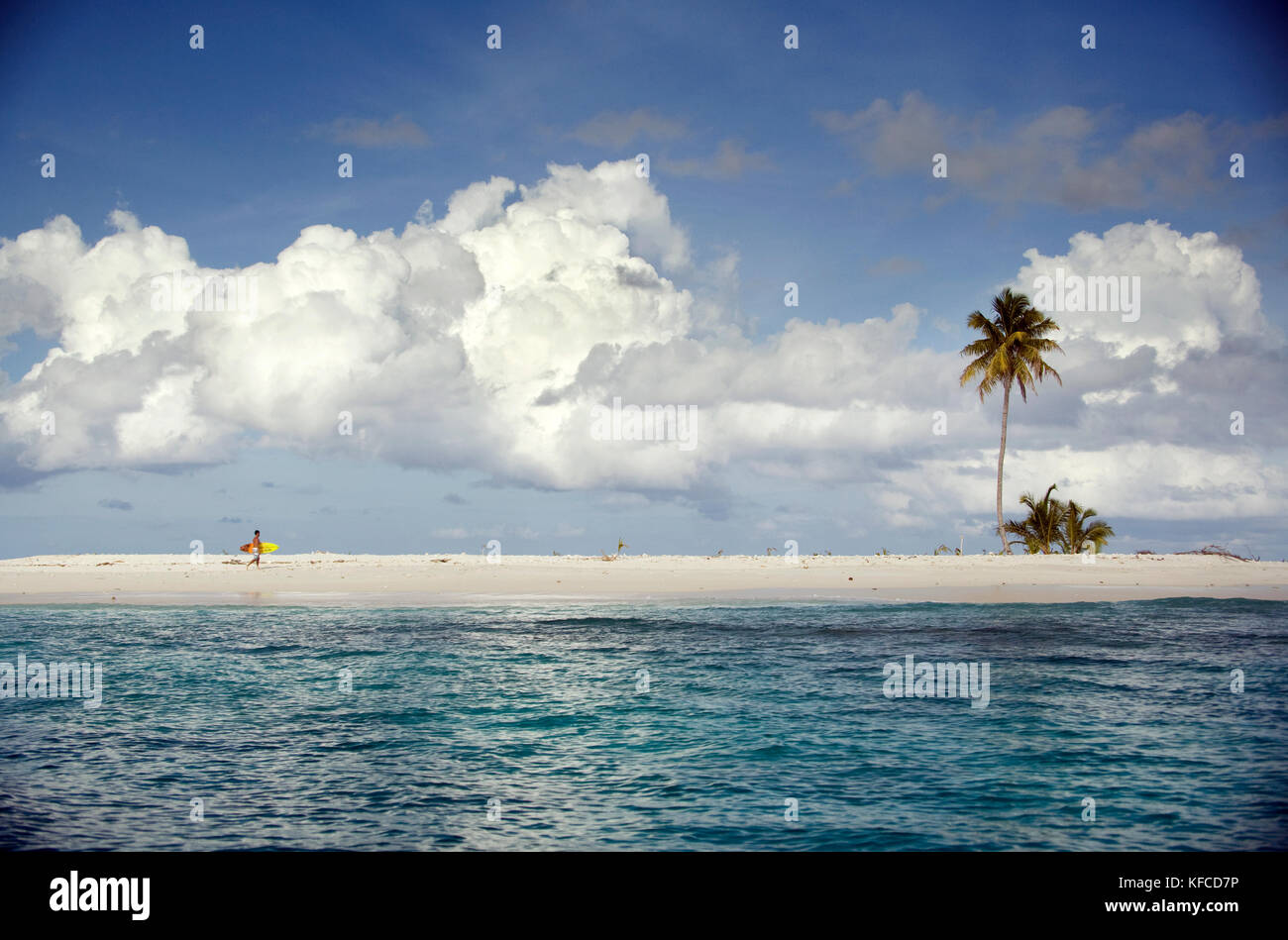 INDONESIA, Mentawai Islands, Kandui Surf Resort, a surfer walking on a ...