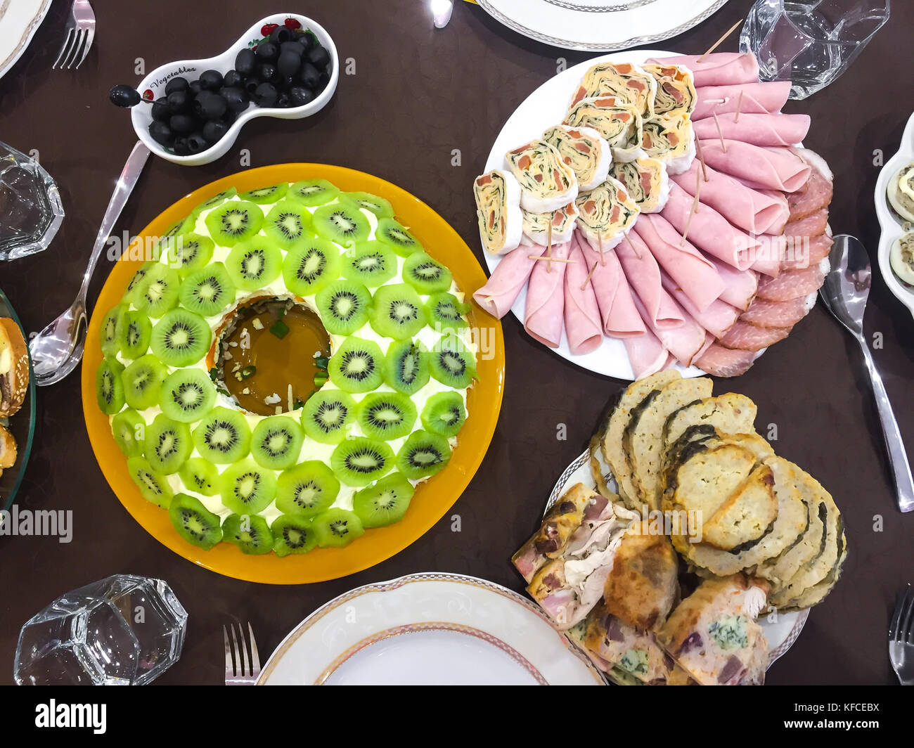 Salad with kiwi, ham, pieces of stuffed turkey, rolls with salmon at a ...