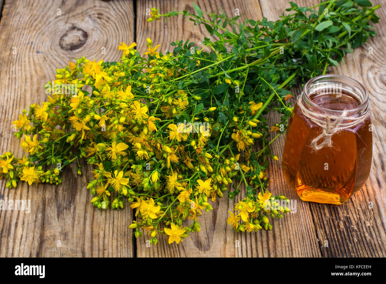 Honey in transparent glass jar and fresh St. John's wort flowers on ...