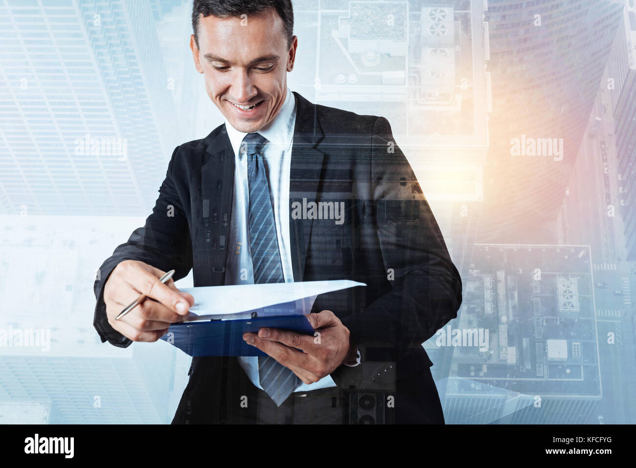 Happy cheerful businessman checking his notes Stock Photo - Alamy